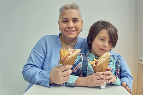 그리스 레스토랑에서 포즈를 취하는 행복한 우크라이나 가족 쾌활한 성인 여성과 주말에 패스트푸드를 먹는 초등학생 2명에 대한 스톡 사진 및 기타 이미지 Istock