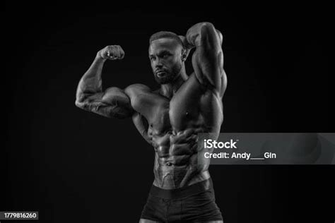 강한 보디 빌더의 실루엣 강력한 몸매와 완벽한 복근을 가진 자신감 넘치는 젊은 피트니스 선수 흑백 사진 드라마틱한 빛 30 34