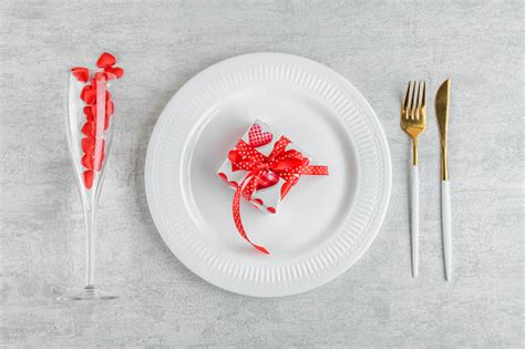 발렌타인 데이 저녁 식사 배경에는 흰색 접시에 선물 수저 밝은 배경에 빨간색 하트가 있는 와인 잔이 있습니다 0명에 대한 스톡 사진 및 기타 이미지 Istock