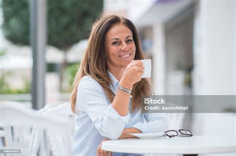 아름 다운 중세 마에 얼굴에 미소와 함께 식당에서 히스패닉 여자 자신감과 밝은 화창한 날에는 테라스에서 커피 한잔 마시는 갈색