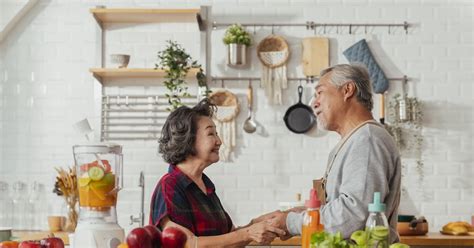 부엌에서 춤을 추는 동안 집에서 함께 건강 한 음식을 요리하는 아시아 노인 성인 주말 주말 행복 아시아 노인 부부는 낭만적 인 춤을 추는 노인 커플의 자른 샷을 즐긴다