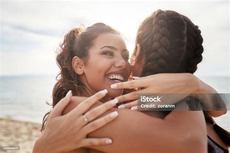 Two Happy Young Women Hugging After Scoring In Beach Volley Game Stock