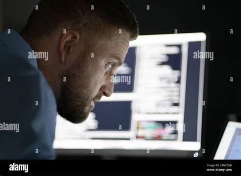 Programmer Working Late At Night On Multiple Computer Screens Stock