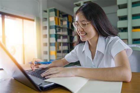 아시아 대학 학생 소녀 독서 책과 노트북 및 스마트 휴대 전화와 함께 작업을 수행 하는 그녀의 숙제에서 공공 도서관에서 교실에 대한 스톡 사진 및 기타 이미지 Istock