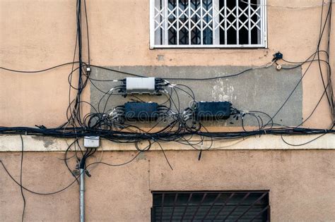Intricate And Chaotic Network Of Fiber Optic Cables Running Along The Exterior Of A Building