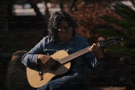 밖에서 기타를 연주하는 안경을 쓴 여자 사진 Unsplash의 기타리스트 이미지