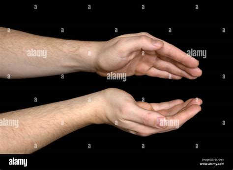 Male Hands Enclosing And Encompassing And Cupping Against Black Stock