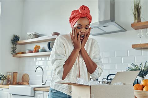 부엌에 서있는 동안 열린 상자를보고 얼굴을 만지는 것에 놀란 아프리카 여성 배달에 대한 스톡 사진 및 기타 이미지 배달 아름다운 여성 열기 Istock