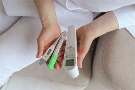 Close Up Female Gp Physician Doctor Holding Different Types Of Thermometers For Measuring Human