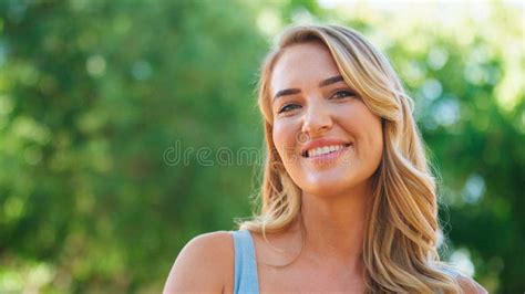 Smiling Woman With Long Blonde Hair Posing Outdoors In Natural Light