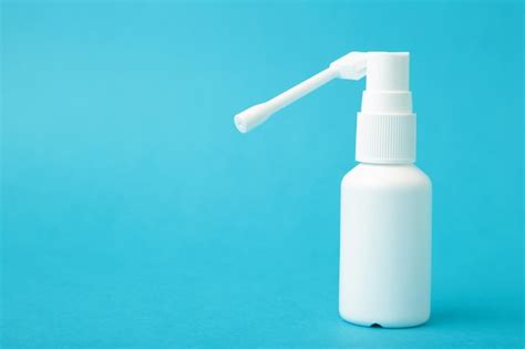 Premium Photo Throat Spray Medication In A White Bottle On Blue