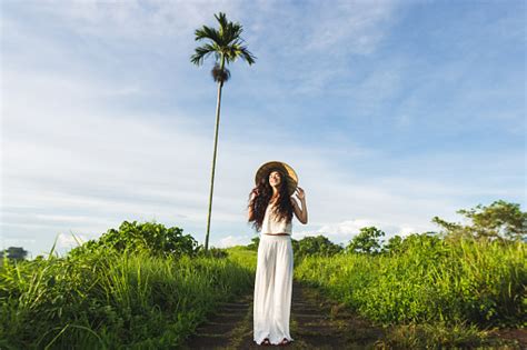 흰 드레스와 배경에 손바닥 전통적인 아시아 밀 짚 모자에 젊은 행복 한 여자의 열 대 세로 갈색 머리에 대한 스톡 사진 및 기타
