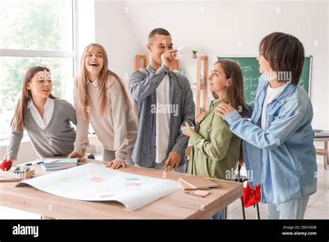 Group Of Teenage Babes Performing Task At Table In Classroom Stock Photo Alamy