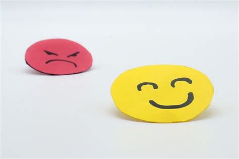 노란색은 배경에 또 다른 빨간색 화난 얼굴과 함께 종이 웃는 얼굴을 잘라냅니다 흰색 바탕에 부러움 이기심 행복 또는 복지의 개념 3차원 형태에 대한 스톡 사진 및 기타