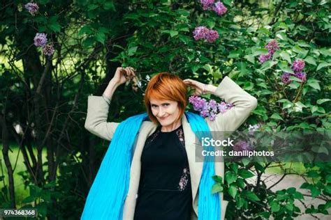 검은 드레스 밝은 코트와 복사 공간 피 라일락의 숲에서 포즈 큰 파란색 목도리에 놀라운 빨간 헤 너 머리 소녀 라일락의 핑크