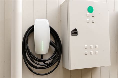집 벽에 전기 자동차 충전기가 있고 옆에 스위치 브레이크 박스가 있습니다 전기 자동차 대체 연료 자동차에 대한 스톡 사진 및 기타 이미지 전기 자동차 대체 연료 자동차