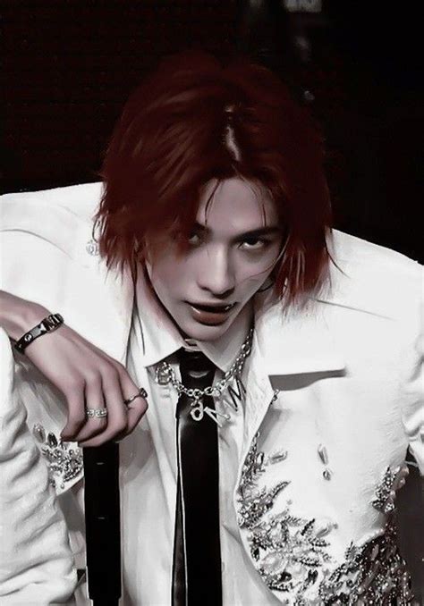 A Man With Red Hair Wearing A White Shirt Black Tie And Silver Bracelets