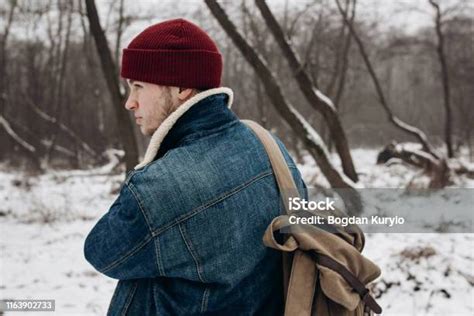 겨울 눈 덮인 숲에서 걷는 빨간 모자에 배낭 세련된 힙스터 여행자 텍스트 공간을 가진 방랑자 및 모험 개념 대기 의 순간 유행 모양 걷기에 대한 스톡 사진 및 기타 이미지