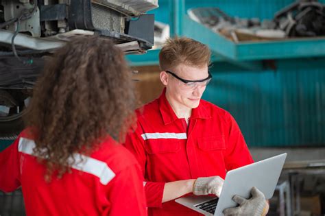 제복을 입은 젊은 정비사 팀이 리프트 차량으로 자동차 서비스를 하고 있습니다 자동차 수리 및 유지 보수 개념 25 29세에 대한 스톡 사진 및 기타 이미지 Istock