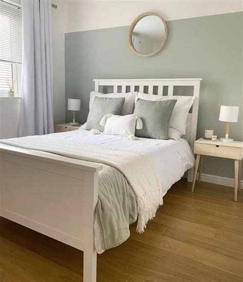 a white bed sitting in a bedroom next to a window