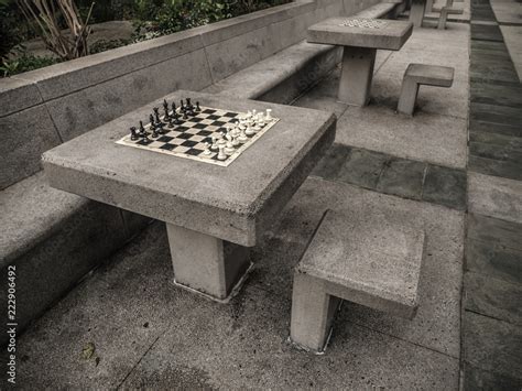 Chess Board And Pieces On Concrete Table And Benches In A Public Park