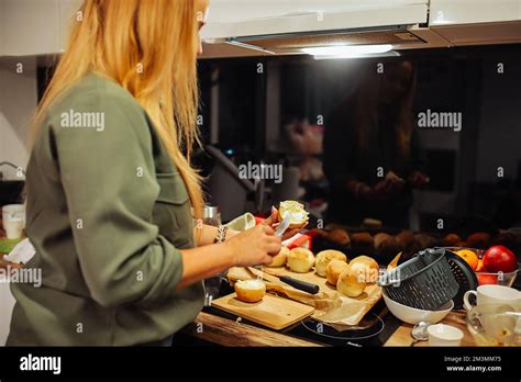 Rearview Of Blond Unrecognizable Woman Cooking Spreading Butter On