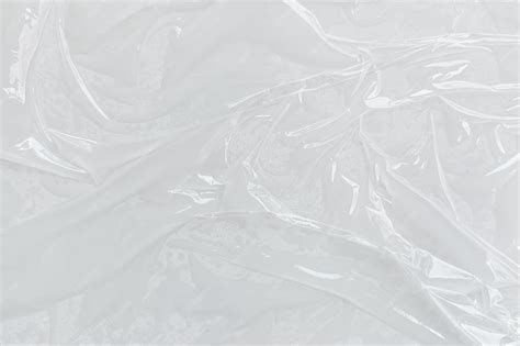 흰색 투명 구겨진 구겨진 플라스틱 포스터 질감 배경 흰색 배경에 젖은 플라스틱 포장 프리미엄 사진