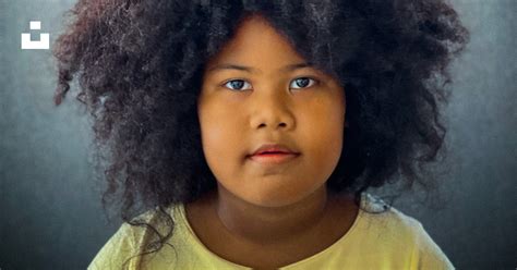 벽 앞에 서 있는 큰 아프리카를 가진 어린 소녀 사진 Unsplash의 무료 라고스 이미지