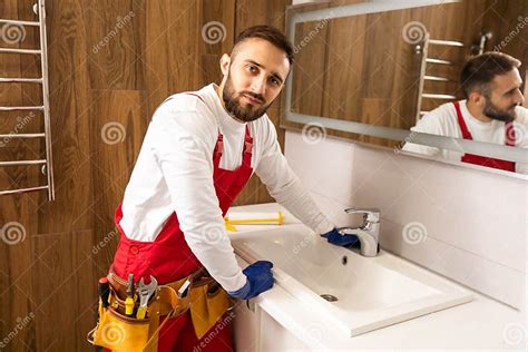 Professional Plumber With Plunger And Instruments Near Sink Stock