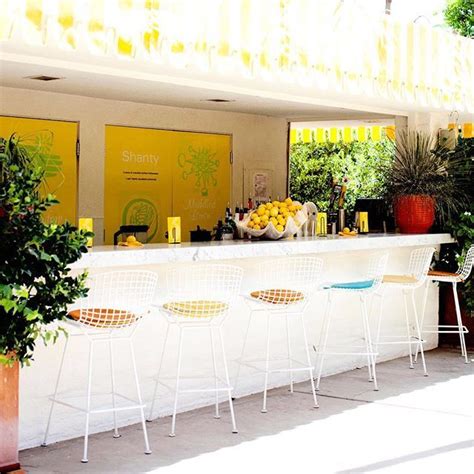 There Are Four Chairs At The Bar With Lemons On It And Two Yellow Vases