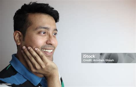 턱에 손을 얹은 아시아 남자의 귀여운 얼굴의 오른쪽 기쁜 느낌과 흰색 배경의 복사 공간을 향해 찾고 개념에 대한 스톡 사진 및 기타 이미지 Istock