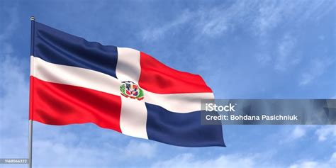 푸른 하늘 배경에 깃대에 도미니카 국기 구름이 있는 하늘을 배경으로 바람에 흔들리는 도미니카 국기 텍스트를 위한 장소입니다 3d