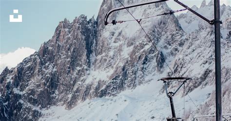 빨간 기차가 눈 덮인 산 옆 선로를 따라 내려갑니다 사진 Unsplash의 무료 바깥 이미지