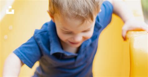 파란색 티셔츠와 파란색 데님 청바지를 입은 소년이 노란색 플라스틱 의자에 앉아 있다 사진 Unsplash의 무료 워싱턴 이미지