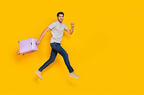 노란색 배경에 고립 된 티셔츠 청바지 운동화를 착용하고 가방을 들고 달리는 멋진 브루넷 젊은 남자의 전체 길이 사진 관광객에 대한 스톡 사진 및 기타 이미지 Istock