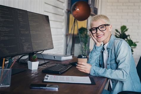 Young Female Programmer At Work Station Coding On Multiple Monitors In