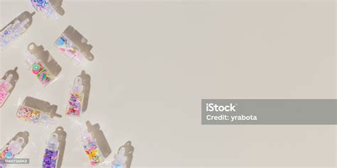 화려한 반짝이는 복사 공간이 있는 베이지색 배경의 작은 항아리에 네일 아트와 메이크업을 위한 다양한 형태입니다 햇빛이 비치는 유리병에 손톱을 꽂기 위해 반짝이는 최소한의