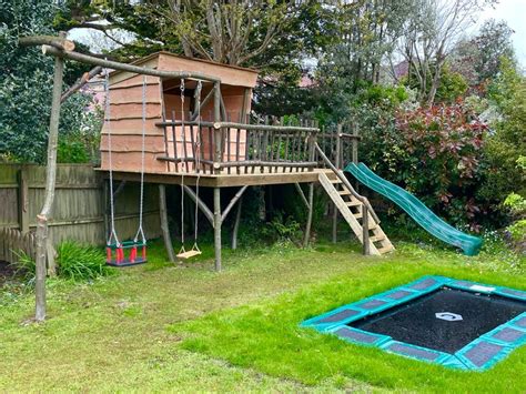 Rustic Treehouse With Swings Climbing Wall And Slide