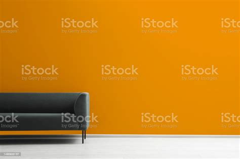 실내 주황색 벽 근처에 세련된 회색 소파 텍스트를 위한 공간 인테리어 디자인 0명에 대한 스톡 사진 및 기타 이미지 0명