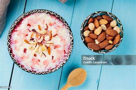 견과류와 장미 물을 곁들인 맛있는 쌀 푸딩 칠해진 파란색 보드에 인도 Kheer 쌀 푸딩 한 그릇 라마단 카림과 이프 타르 무슬림 음식 0명에 대한 스톡 사진 및 기타