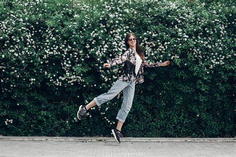 조 팝 나무의 흰 꽃으로 피 부시 대통령의 배경에 재미 선글라스에 행복 Hipster 여자 Boho 소녀 점프 하 고 여름