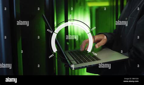 System Administrator Typing On Laptop In Data Center Server Room With