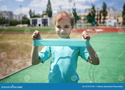 Preteen Girl Making Exercises With Fitness Resistance Band At Public Sportsground In City Sport