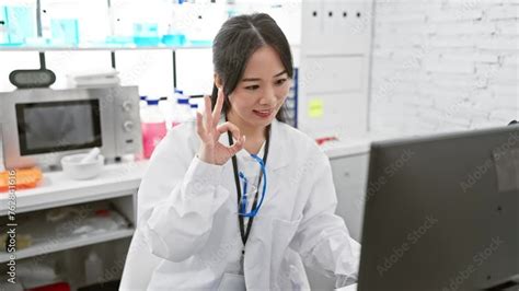Confident Babe Chinese Scientist Woman Radiant With Success Flashes An Ok Sign Flashing