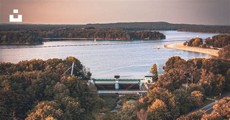 회색 하늘 아래 푸른 나무 근처 바다에 흰색과 검은 색 배 사진 Unsplash의 무료 자연 이미지