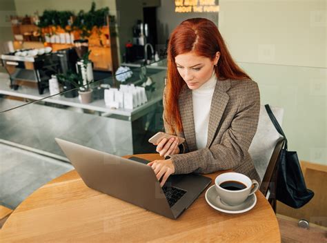 Young Female Entrepreneur Working In A Coffee Shop Woman With Ginger