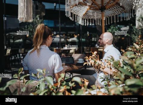 Startup Team In Business Meeting Brainstorming And Strategizing Ideas At An Outdoor Cafe Stock