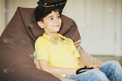男孩戴着虚拟现实眼镜在室内玩游戏