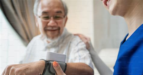 양로원에서 노인 노인을 돌보는 아시아 젊은 여성 간호사가 소파에 앉아 있다 간병인 치료사 의사가 노인 환자를 검사하는 것은