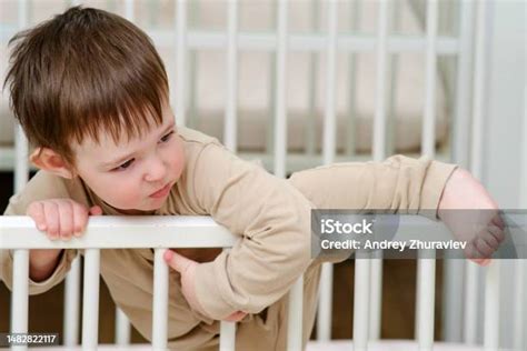 아기는 막대를 기어 올라 유아용 침대에서 탈출합니다 아이는 난간 침대 위로 올라갑니다 2세 정도 정도의 아이 아기에 대한 스톡 사진 및 기타 이미지 Istock